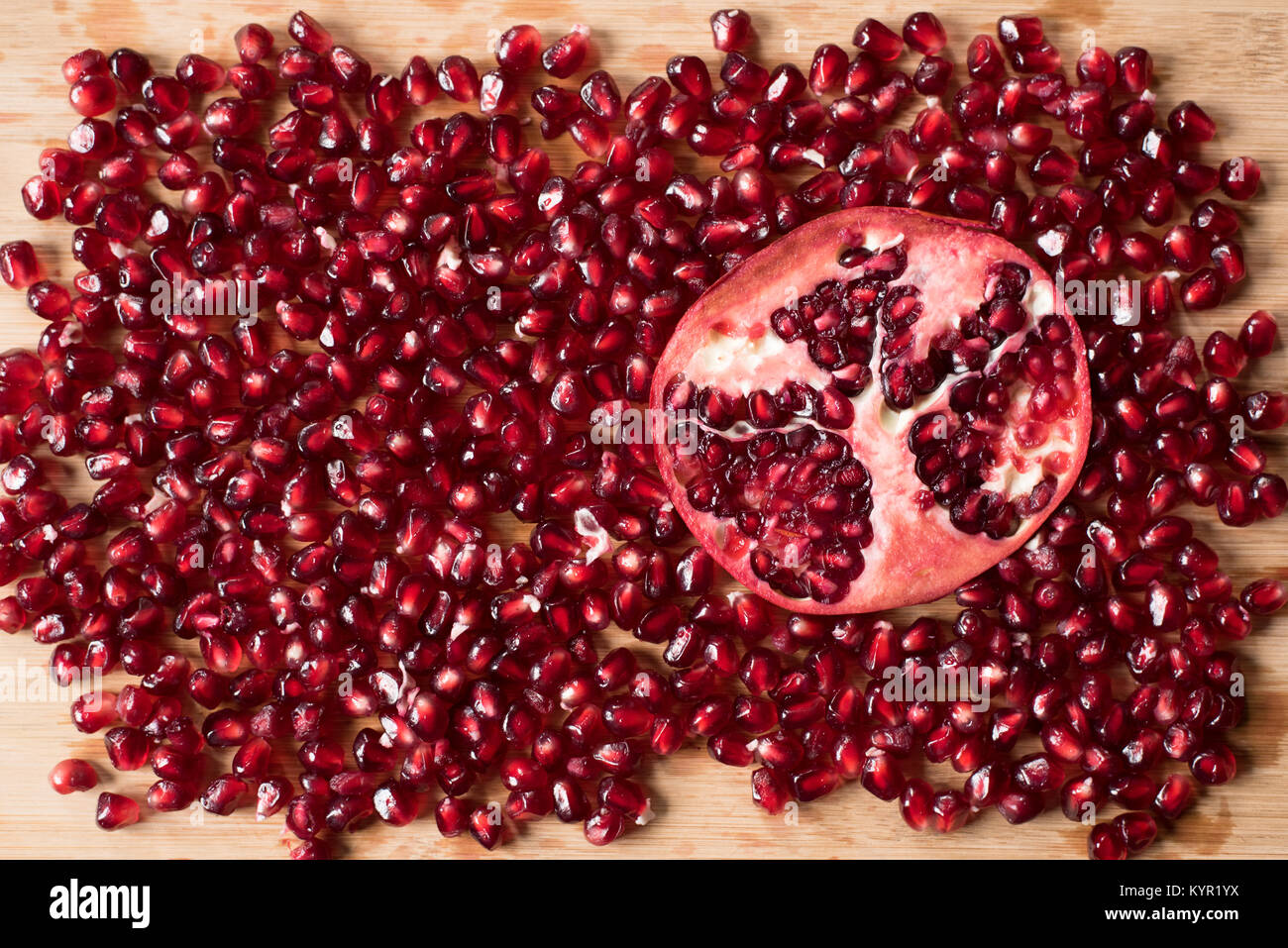 cross section of pomegranate and pomegranate seeds on wooden board ...