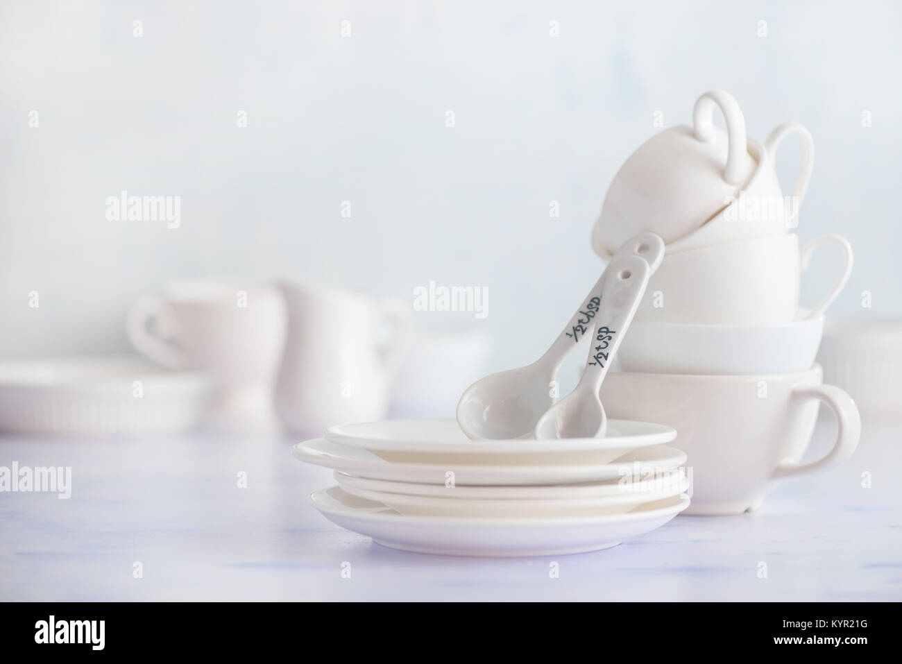 Stack of teatime tableware. Porcelain cups and saucers on a white ...