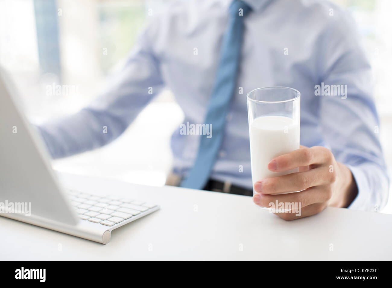 Young businessman drinking milk in office Stock Photo - Alamy