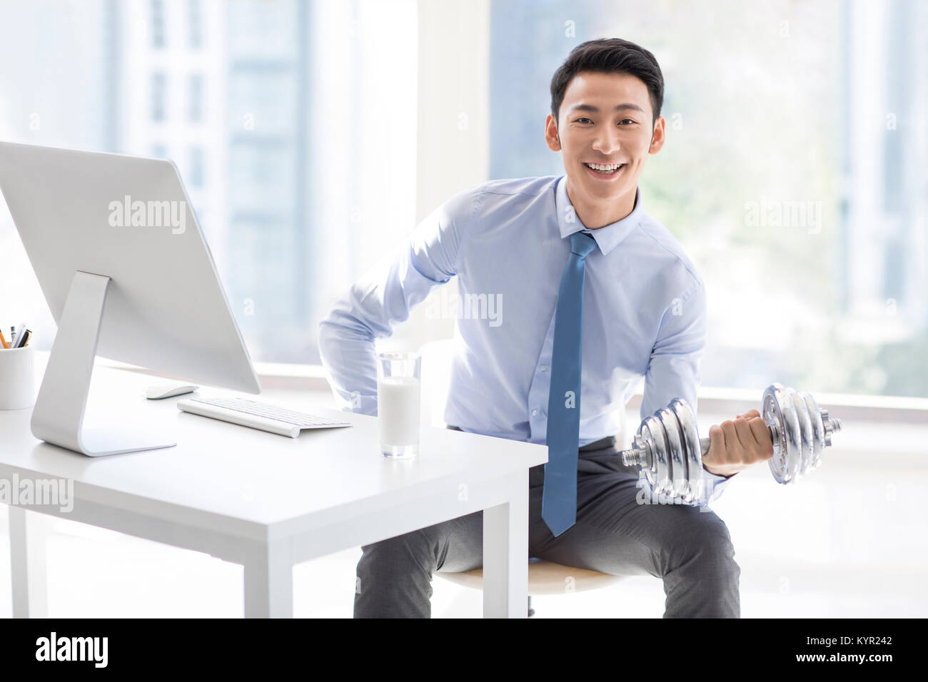 Young businessman exercising in office Stock Photo - Alamy