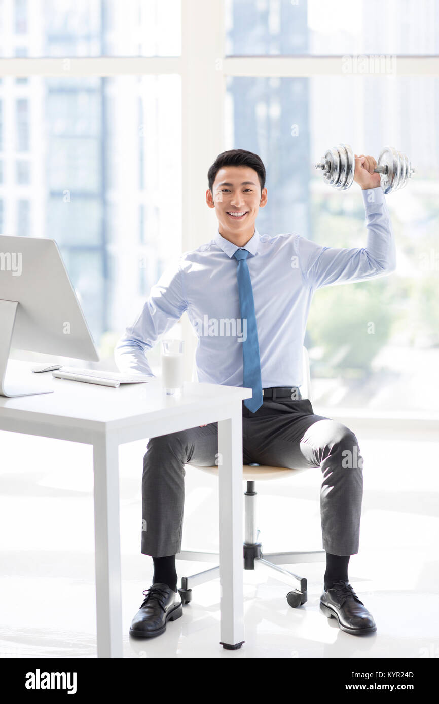 Young businessman exercising in office Stock Photo - Alamy