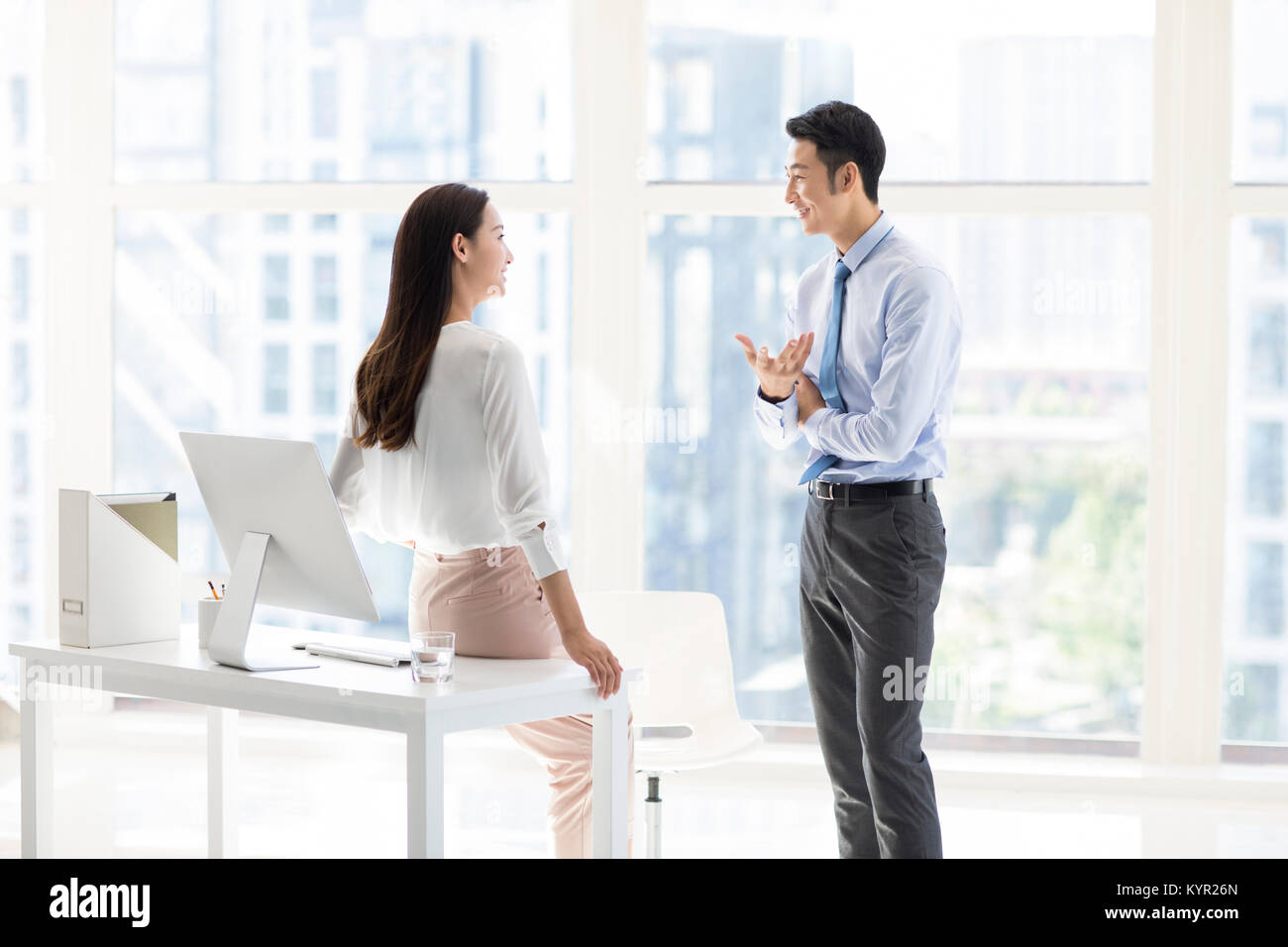 Confident business people talking in office Stock Photo - Alamy