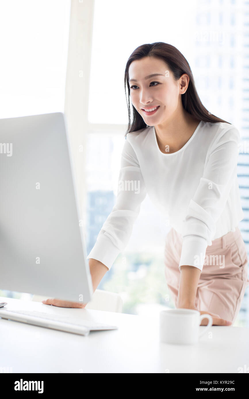 Young businesswoman using computer in office Stock Photo - Alamy