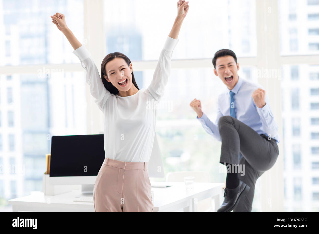 Confident business people cheering in office Stock Photo - Alamy