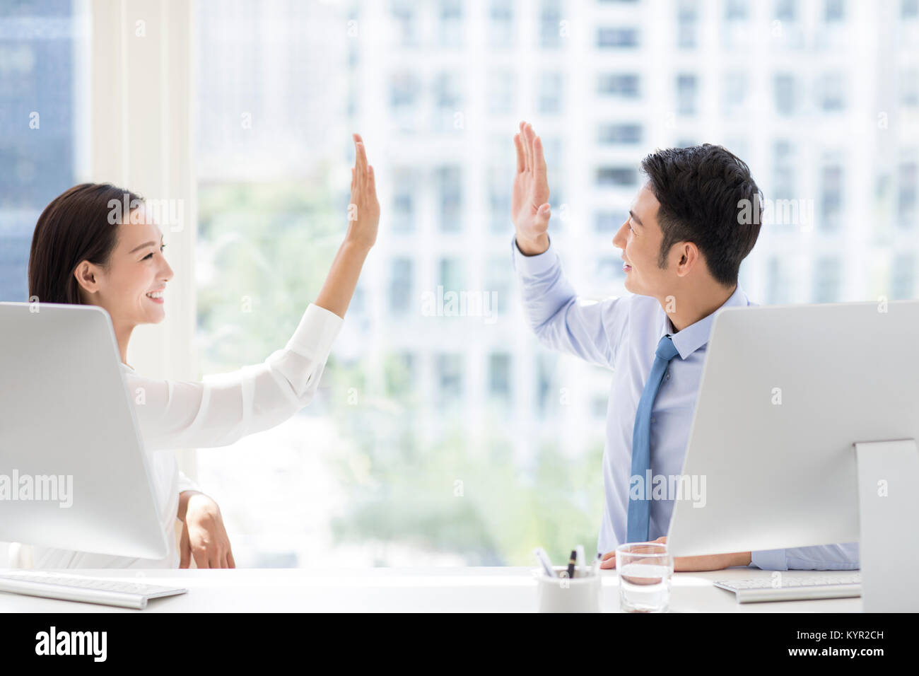 Confident business people high fiving in office Stock Photo - Alamy