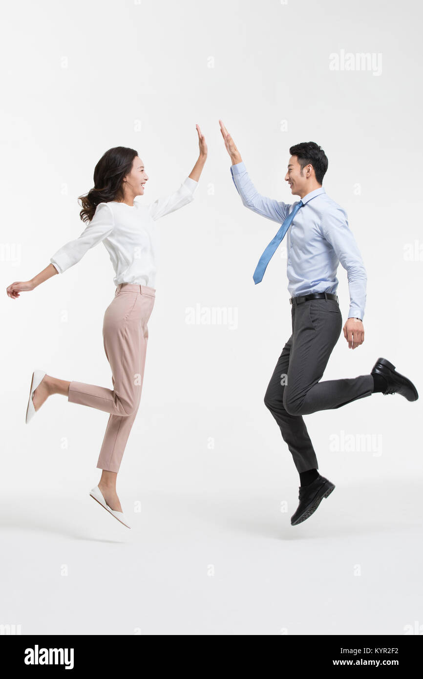 Young business people high fiving Stock Photo - Alamy