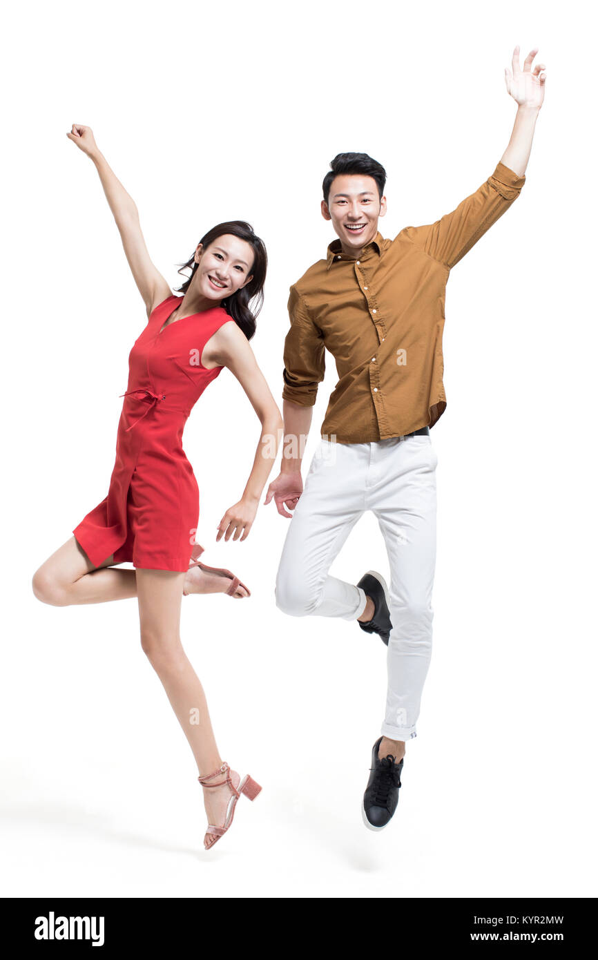Cheerful young couple jumping Stock Photo - Alamy