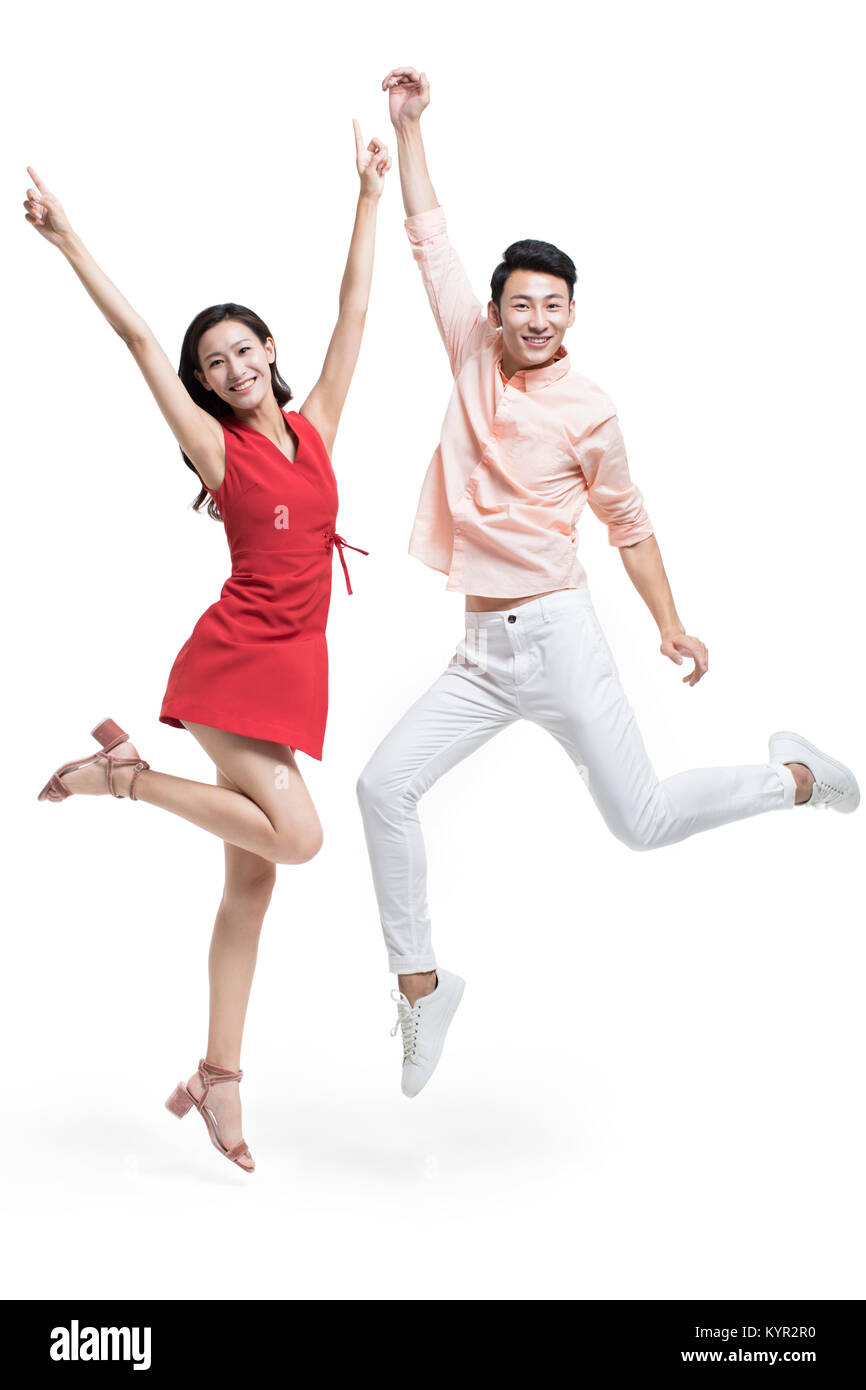 Cheerful young couple jumping Stock Photo - Alamy