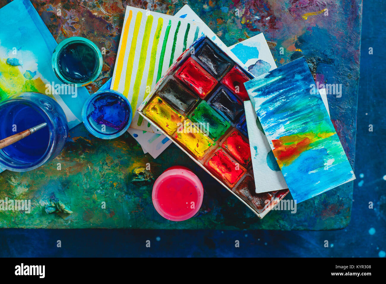 Header with brushes, watercolor paints and sketches. Artist tools on a ...