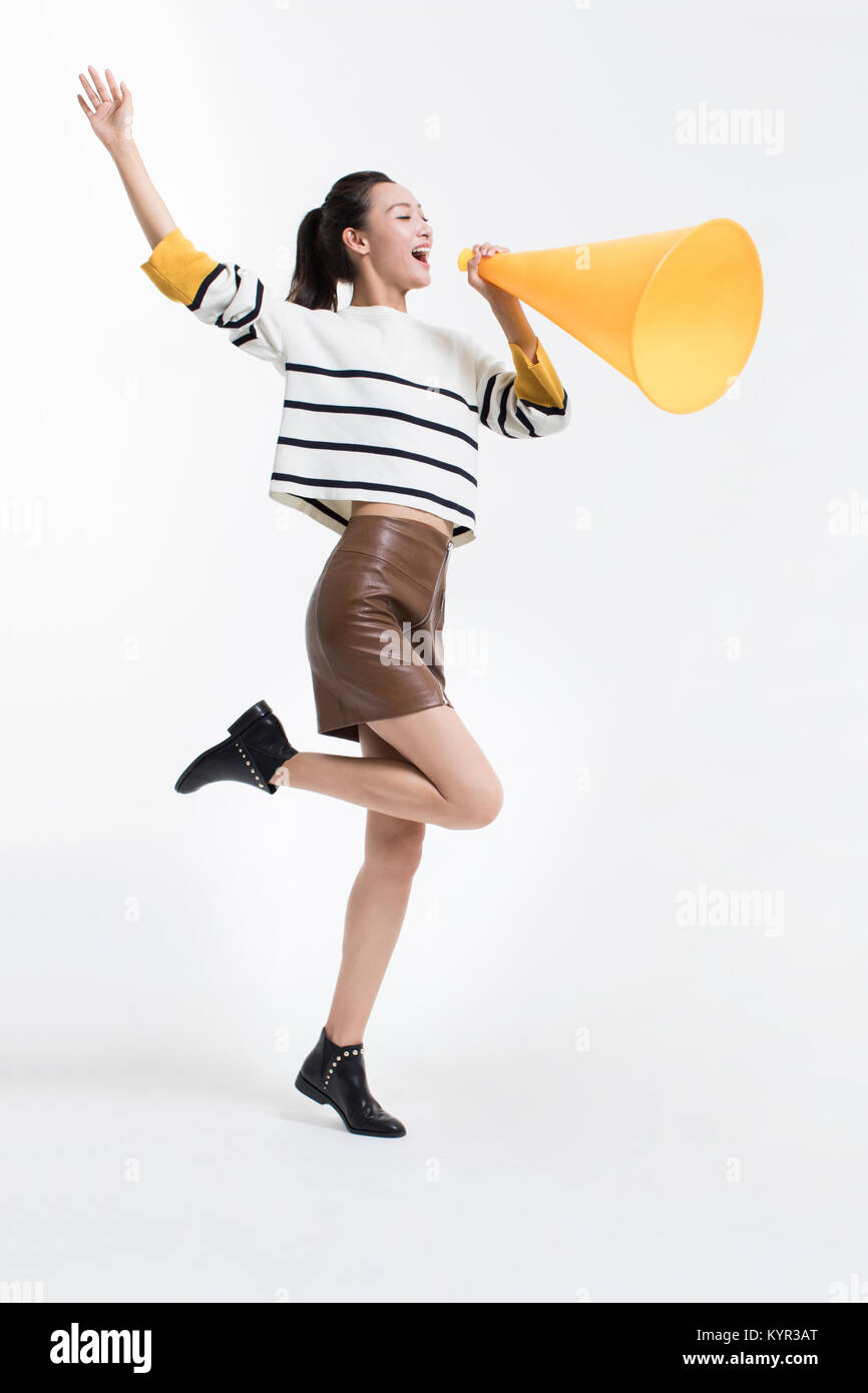 Young woman shouting through megaphone Stock Photo - Alamy