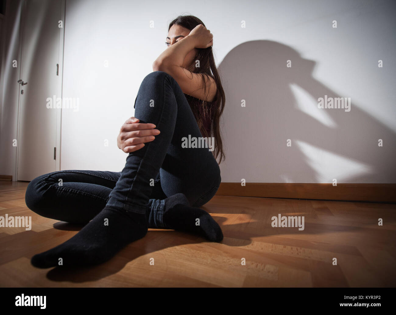 Depressed woman sitting on floor in empty room, female suffering from ...