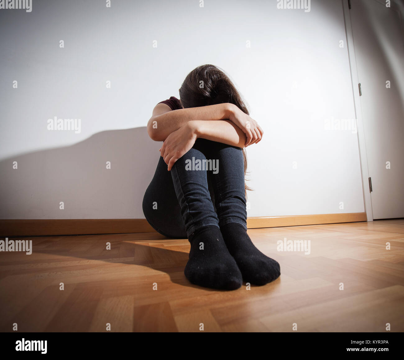 Depression teenager sitting on floor in empty room Stock Photo - Alamy