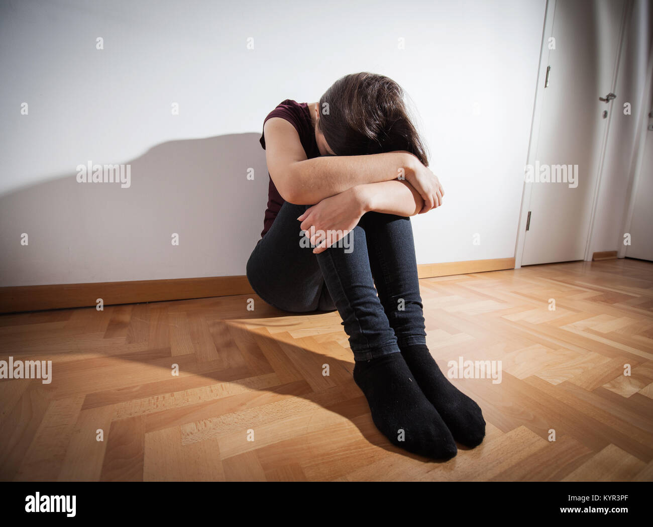 Depression teenager sitting on floor in empty room Stock Photo - Alamy