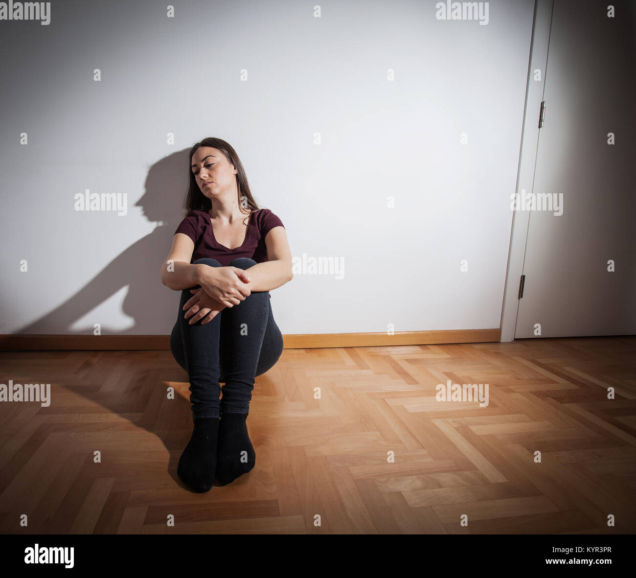 Depression teenager sitting on floor in empty room Stock Photo - Alamy