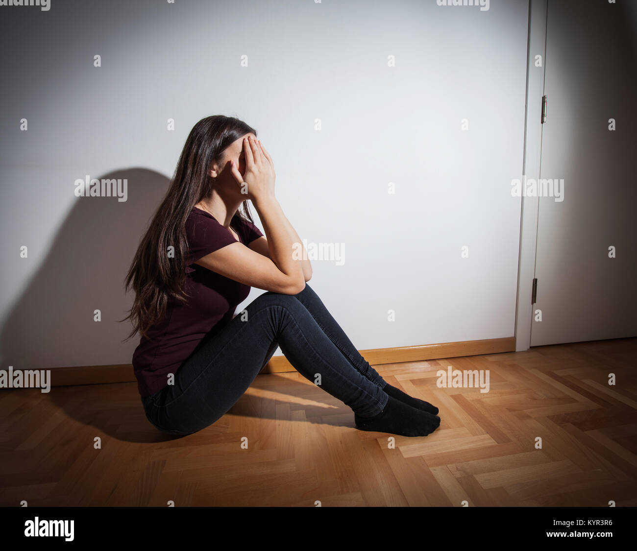 Depression teenager sitting on floor in empty room Stock Photo - Alamy