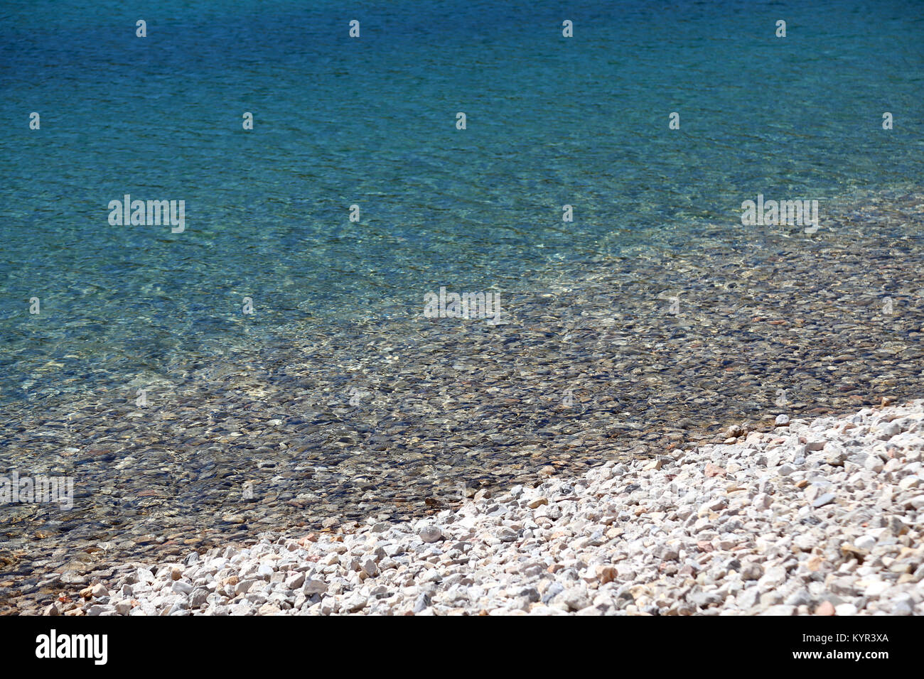 pure and crystalline water of the alpine lake with pebbles on the shore ...