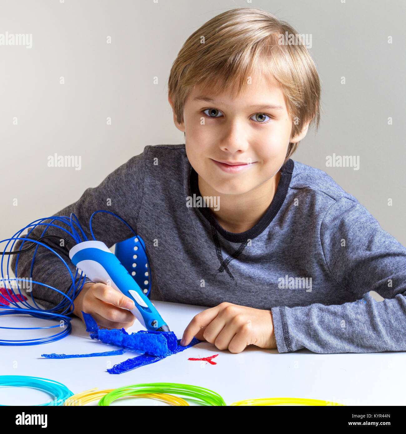 Smiling boy creating with 3d printing pen Stock Photo - Alamy