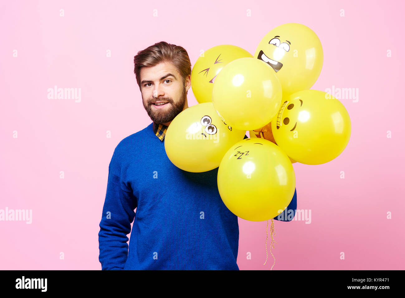 Handsome man holding bunch of balloons Stock Photo - Alamy
