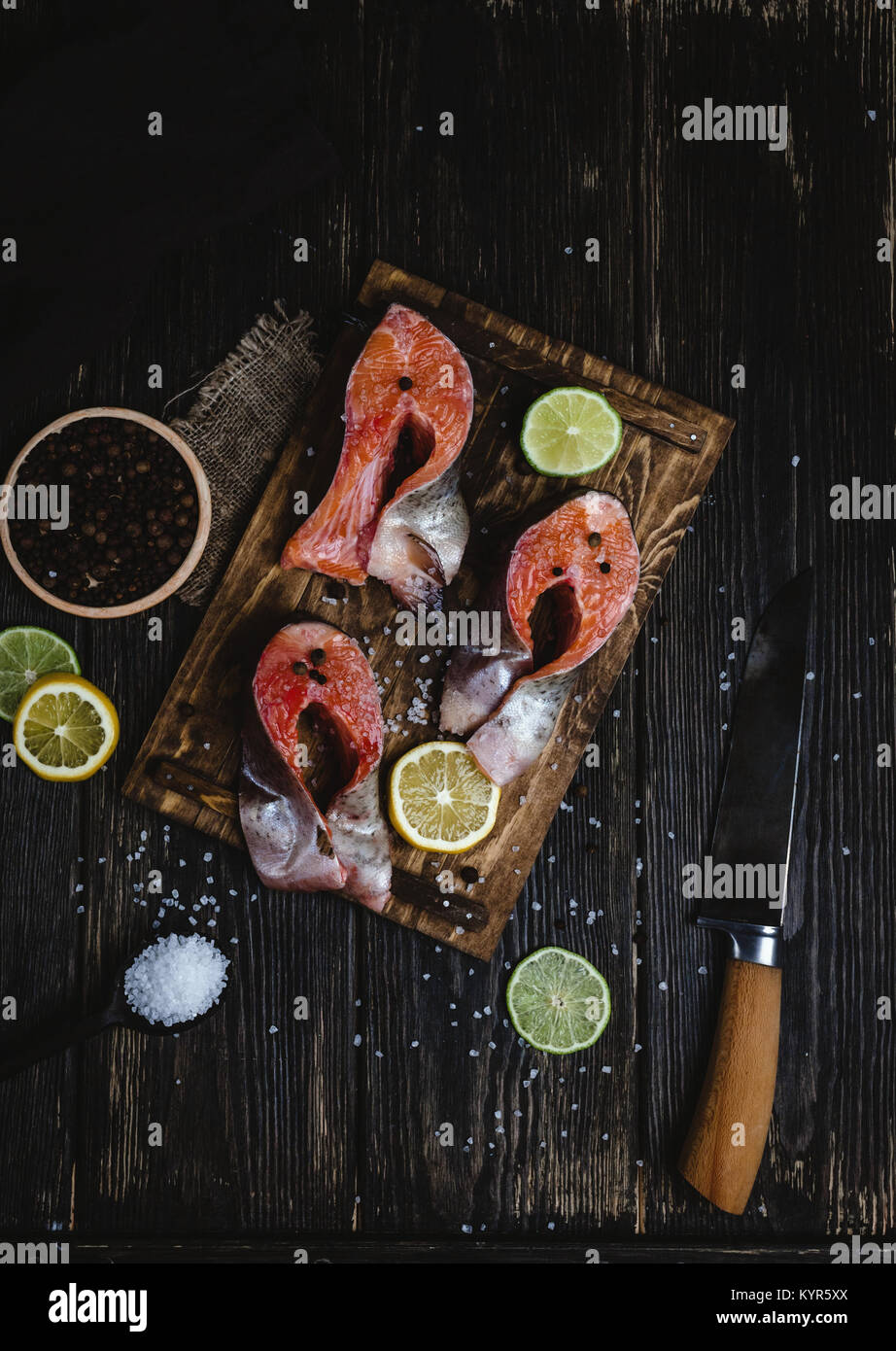 top view of fresh sliced red fish with spices and slices of citrus ...