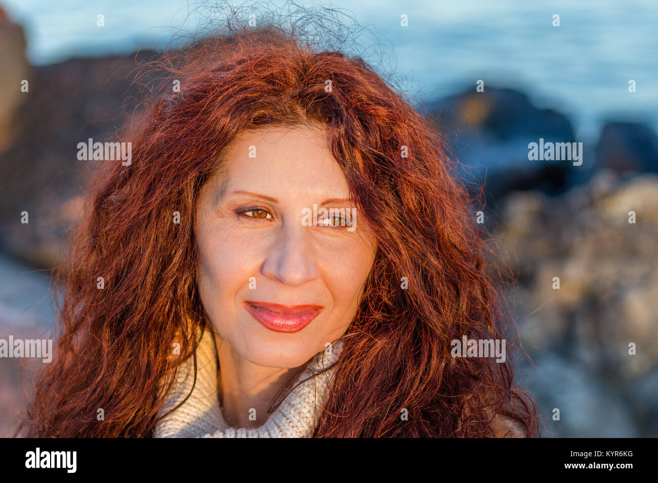 menopausal woman with red copper hair and sun-lit face smiling Stock ...