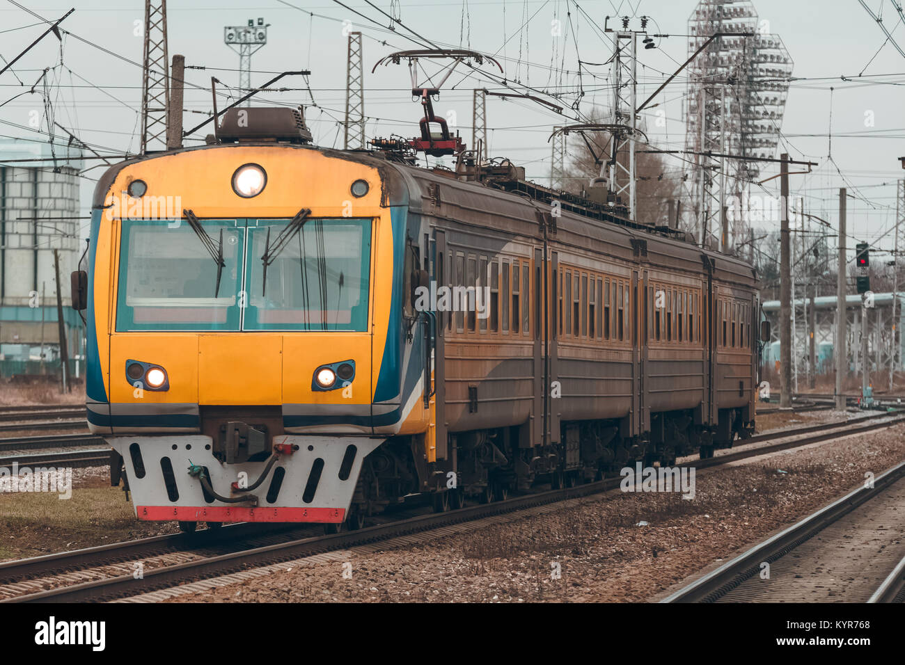 Yellow modern passenger electric train moving at the old terminal Stock ...