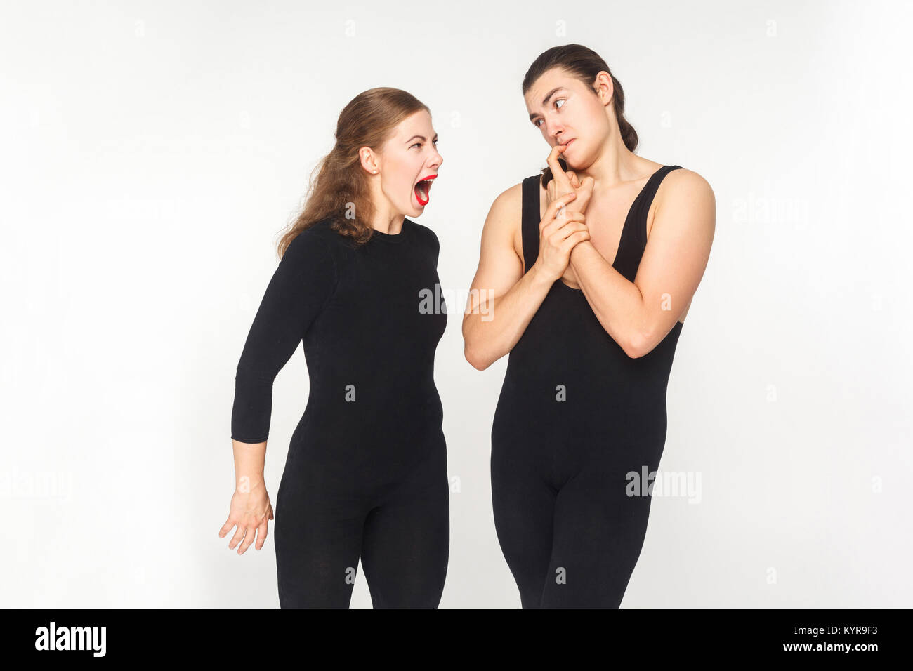 Woman angry and roar at man. Man have a funny look. Studio shot ...