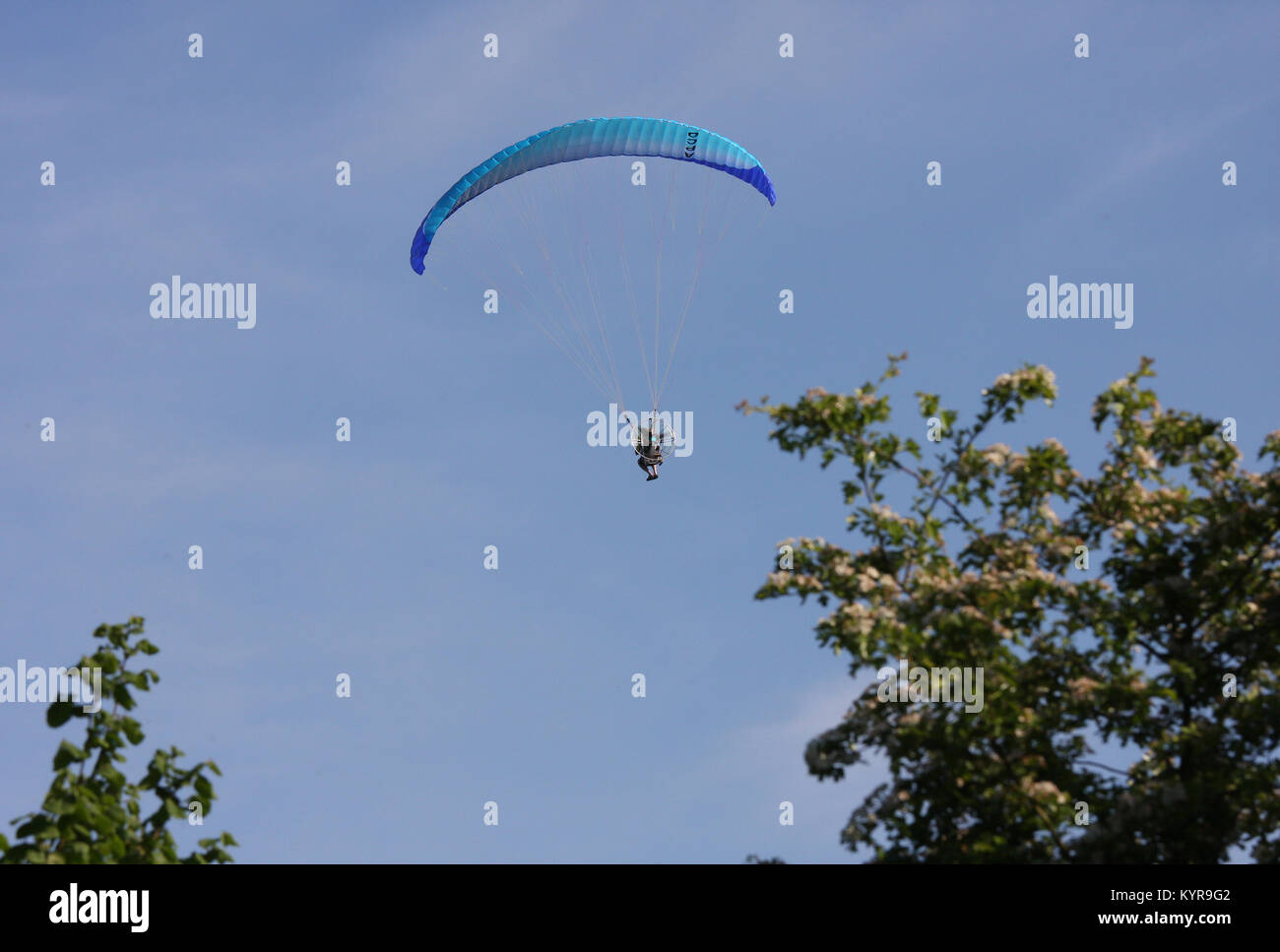 A paraglider flying in blue sky. Paragliding or paramotoring is a form ...