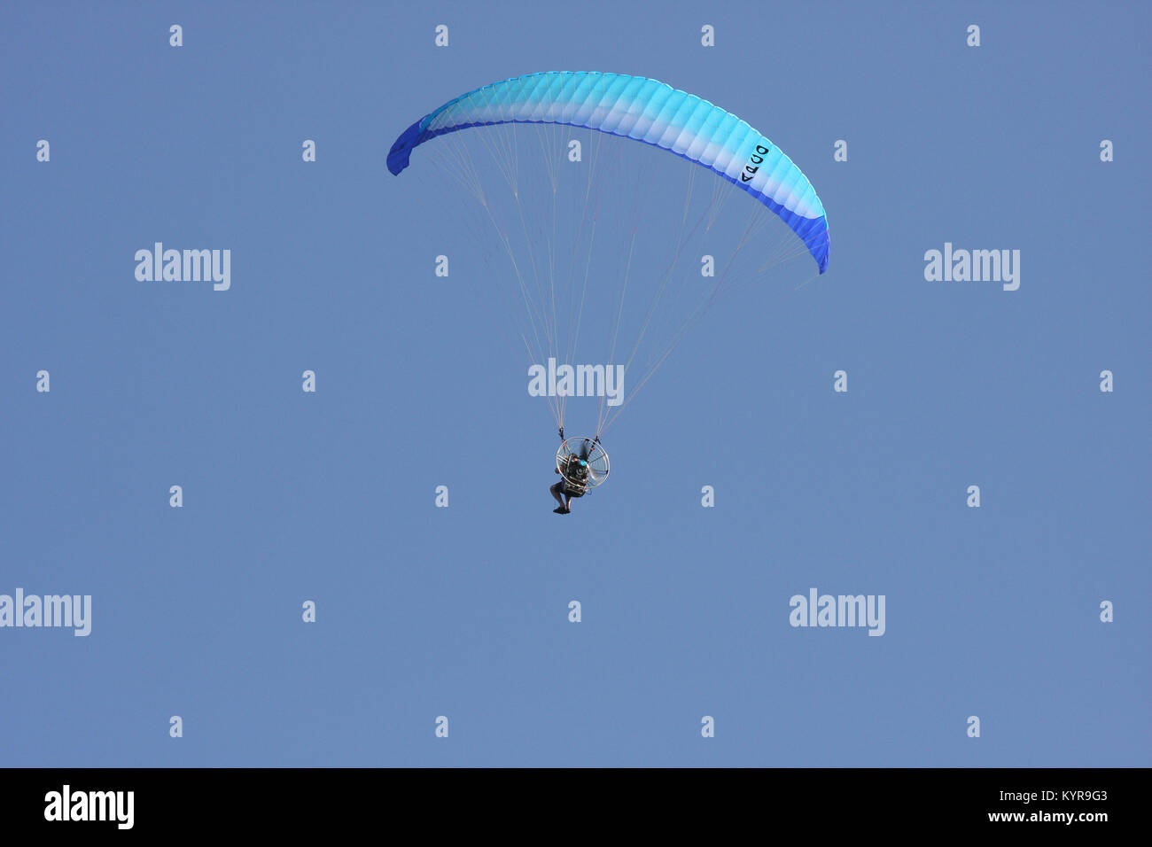 A paraglider flying in blue sky. Paragliding or paramotoring is a form ...