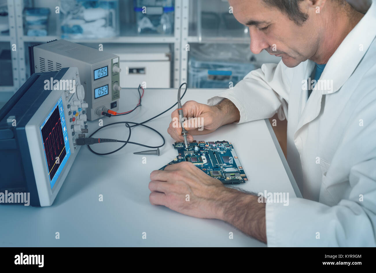 Senior male tech works in hardware repair facility fixing faulty ...