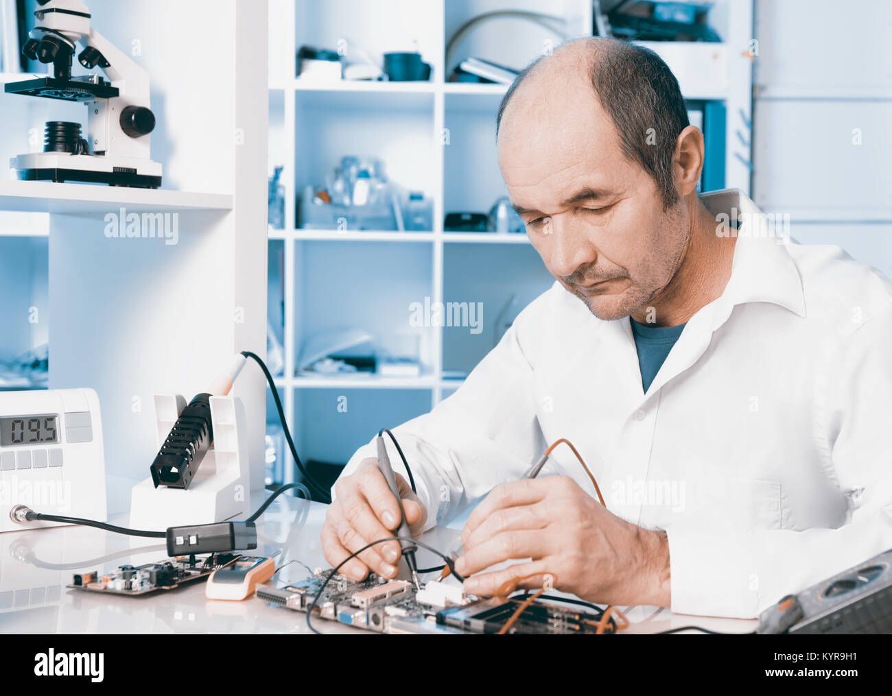 Senior male tech tests electronic equipment, toned image Stock Photo ...