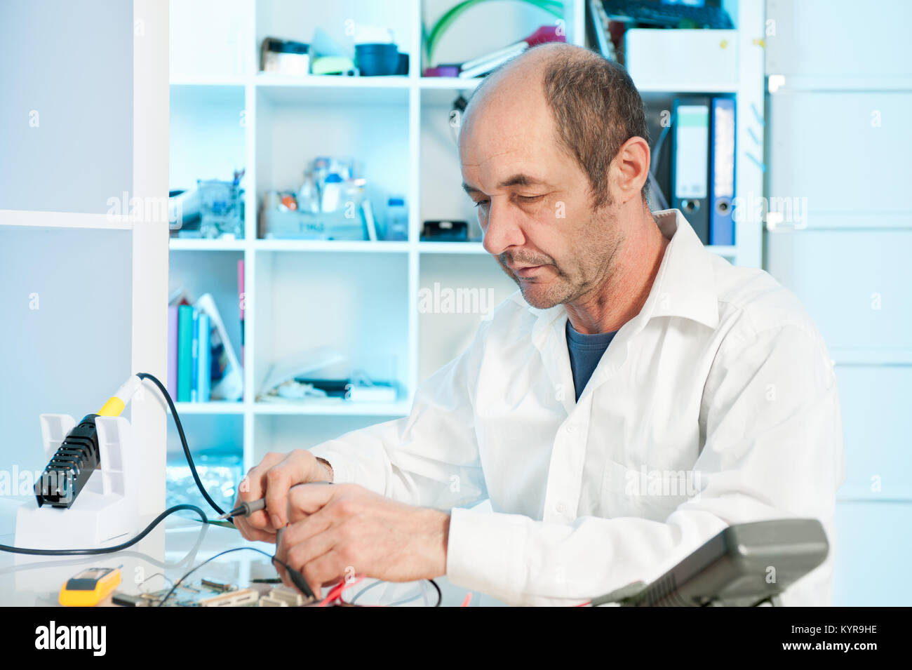 Senior repair tech tests electronic cuircit board Stock Photo - Alamy