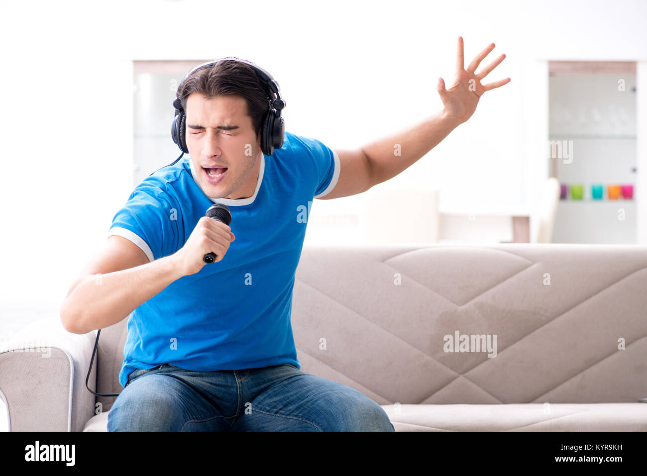 Young man singing at home karaoke Stock Photo - Alamy