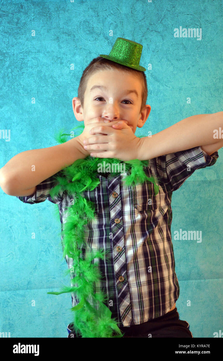 A young boy dressed in St. Patrick's Day garb holds his hands over his ...