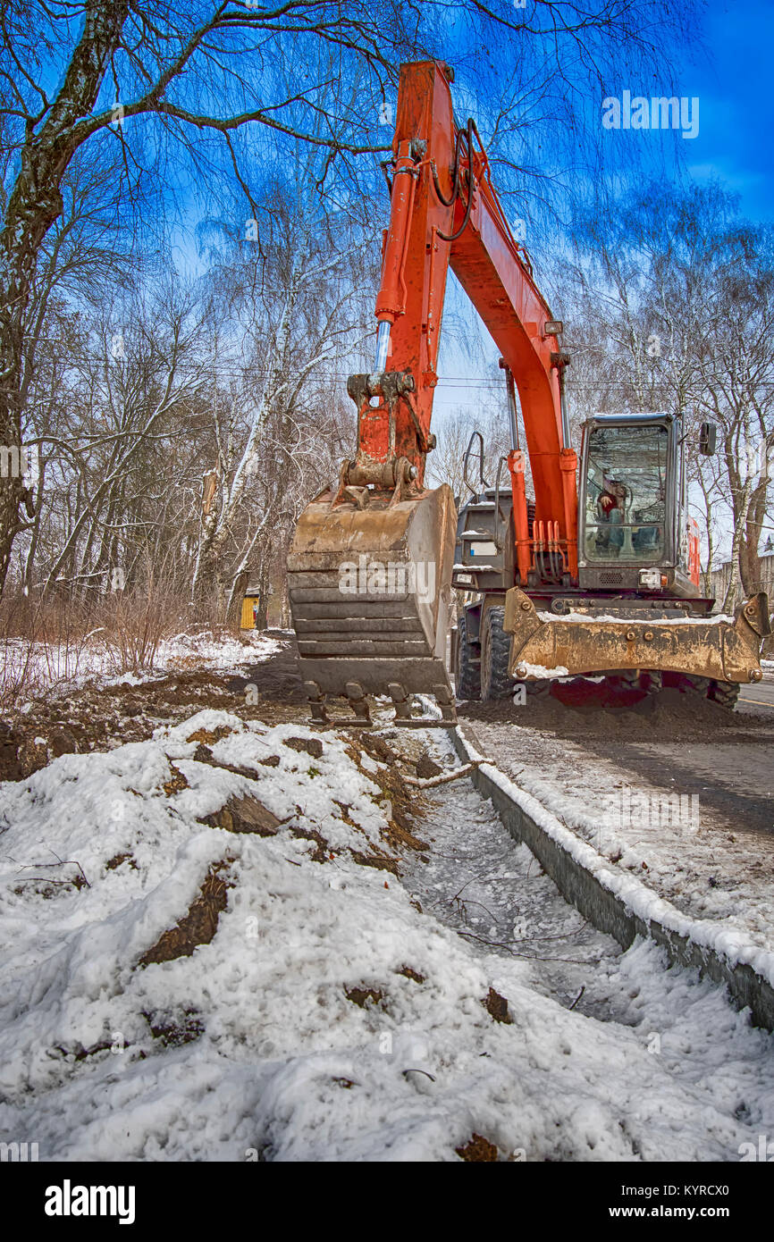 excavator clean the snow from roads and sidewalks in winter Stock Photo ...