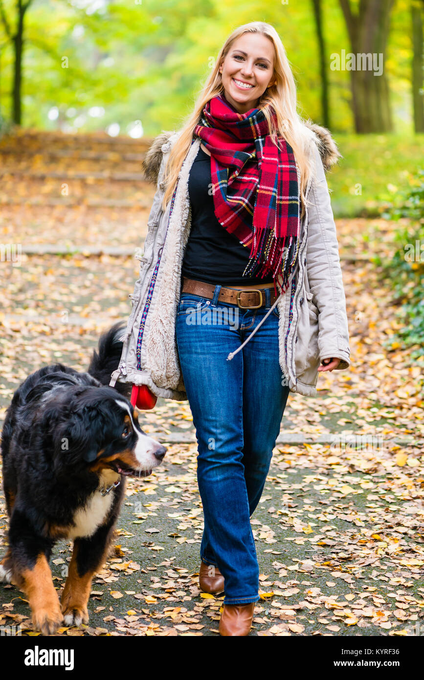 Woman walking the dog on leash in park Stock Photo - Alamy