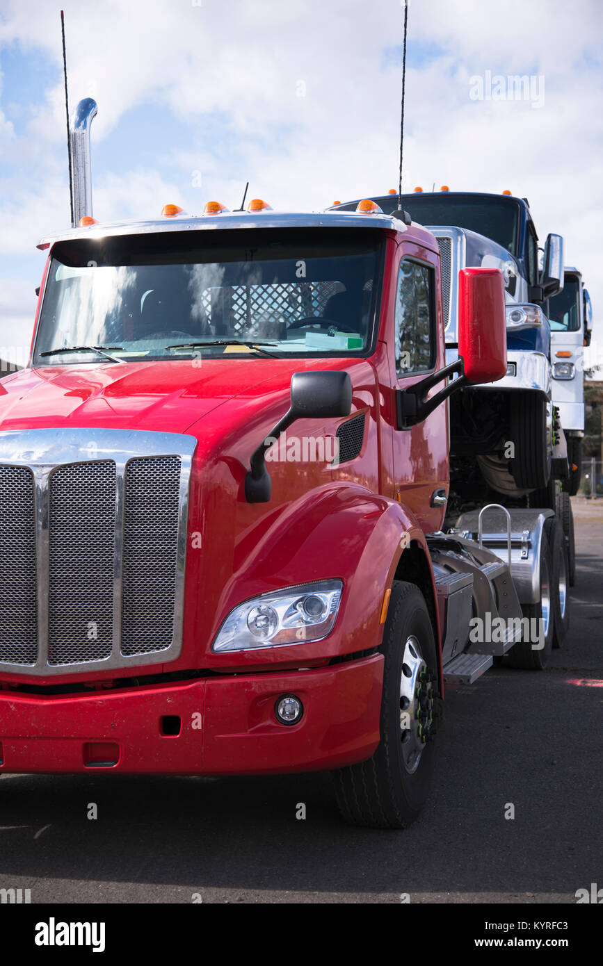 A powerful big rig bright red semi truck with reflection carries other ...