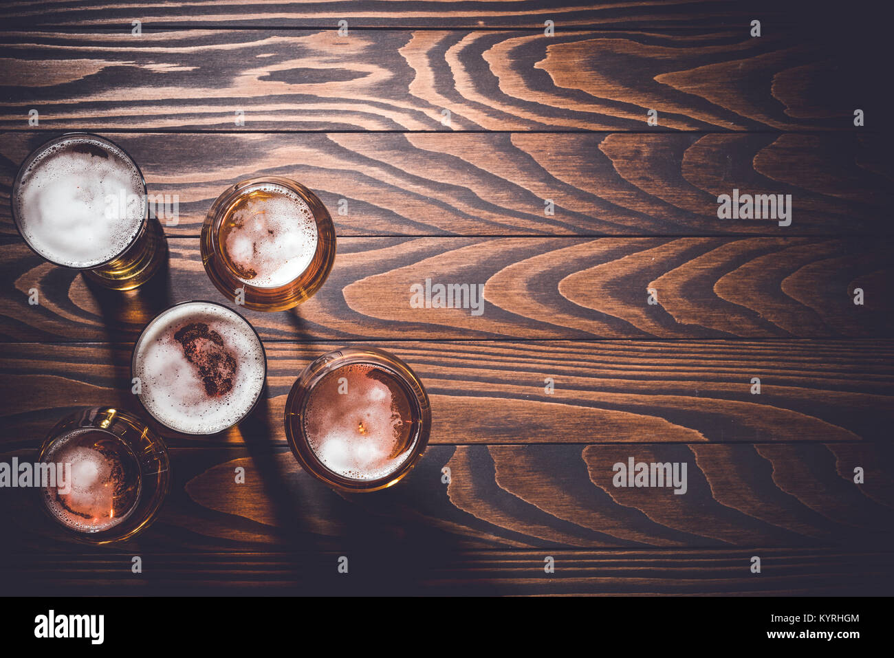 Beer glasses on an old dark wooden table. Top view Stock Photo - Alamy