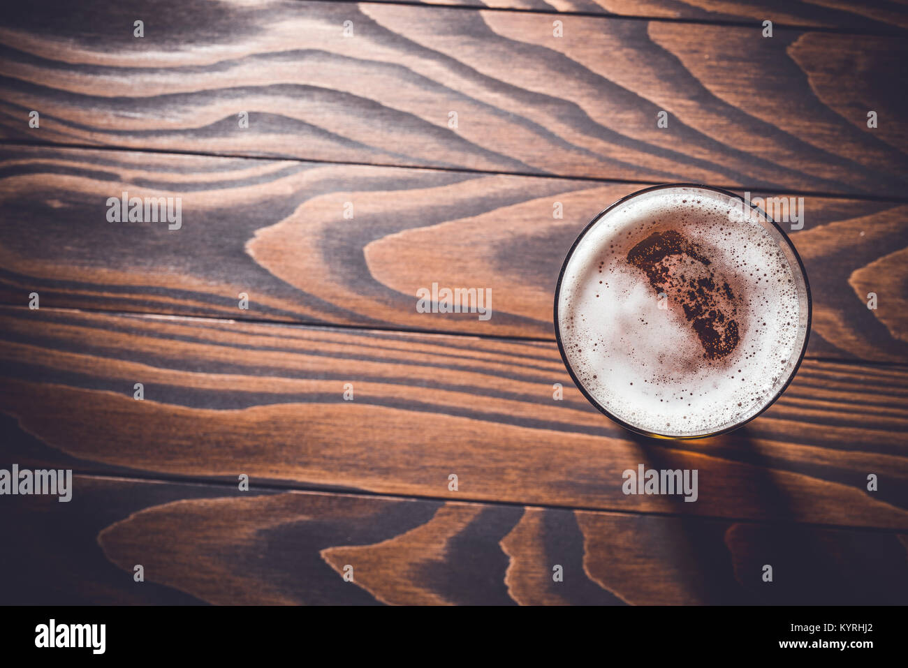 Beer glass on an old dark wooden table. Top view Stock Photo - Alamy