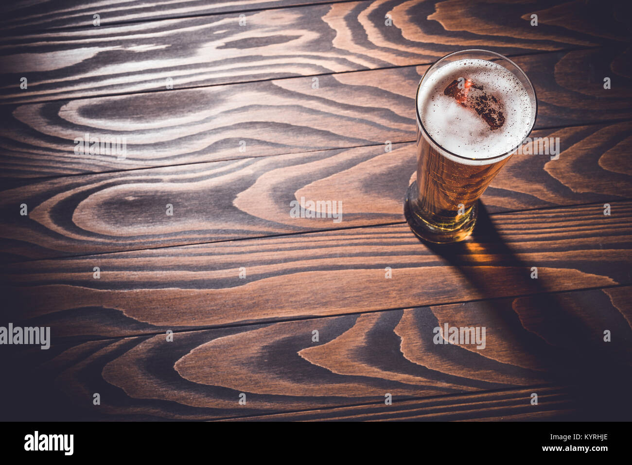 Beer glass on an old dark wooden table. Top view Stock Photo - Alamy