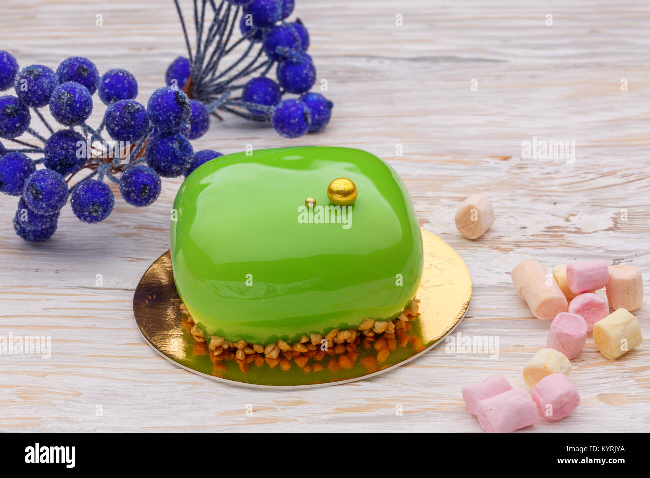 Still life green mousse cake with marshmallow over white wooden ...