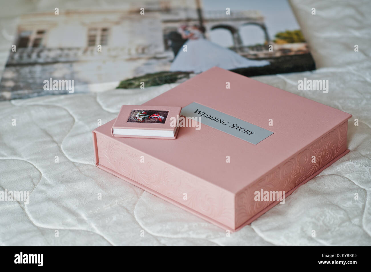 Gentle pink wedding photobook or photo album, box, and cd case laying ...