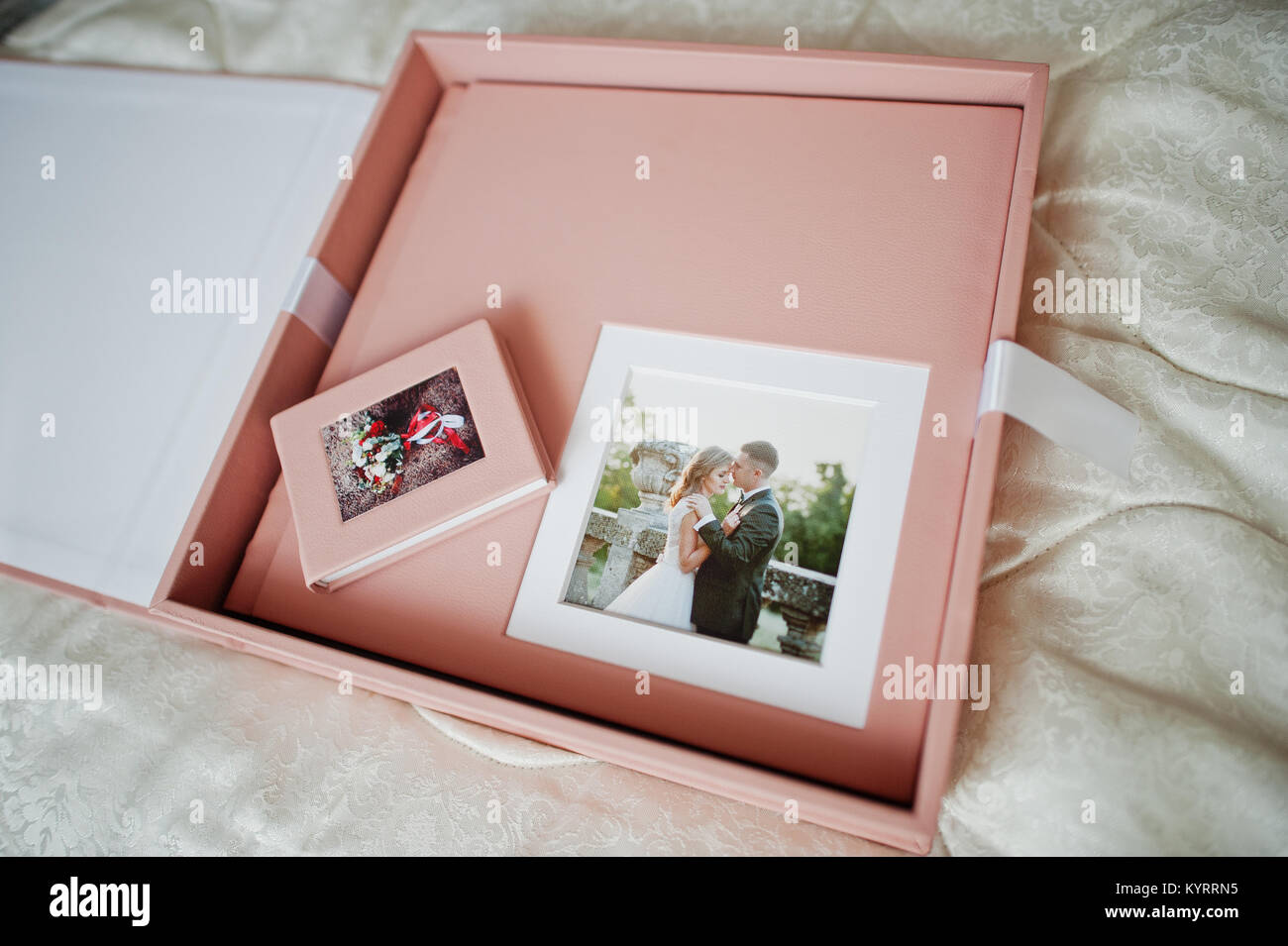 Gentle pink wedding photobook or photo album, box, and cd case laying ...