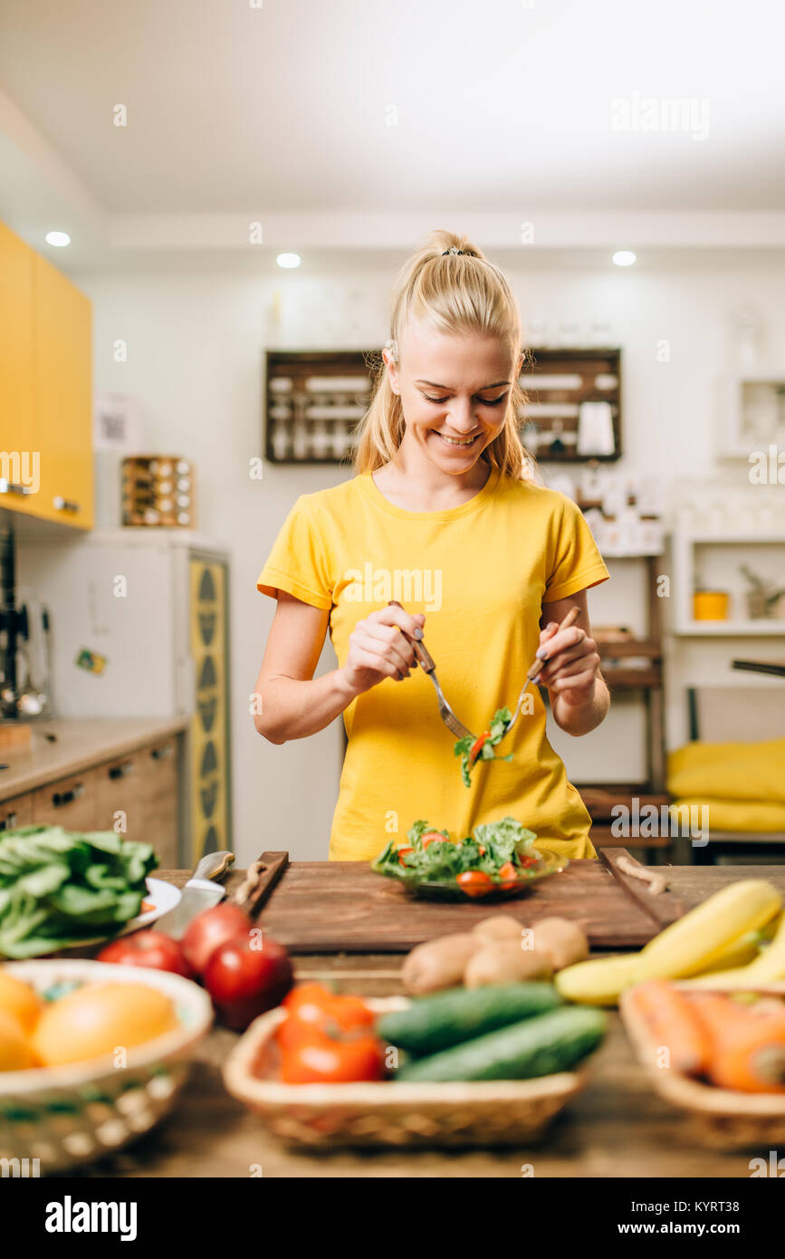 Smiling woman cooking on the kitchen, healthy eco food preparation ...