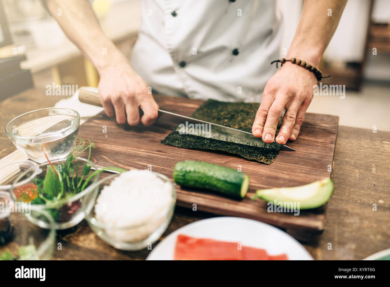 Sushi preparation, traditional japanese food. Male cook making rolls on ...
