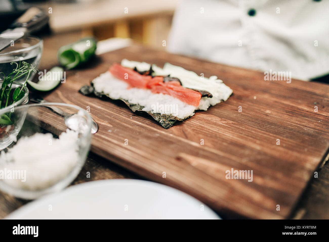 Male cook making sushi on wooden table, top view, asian food ...