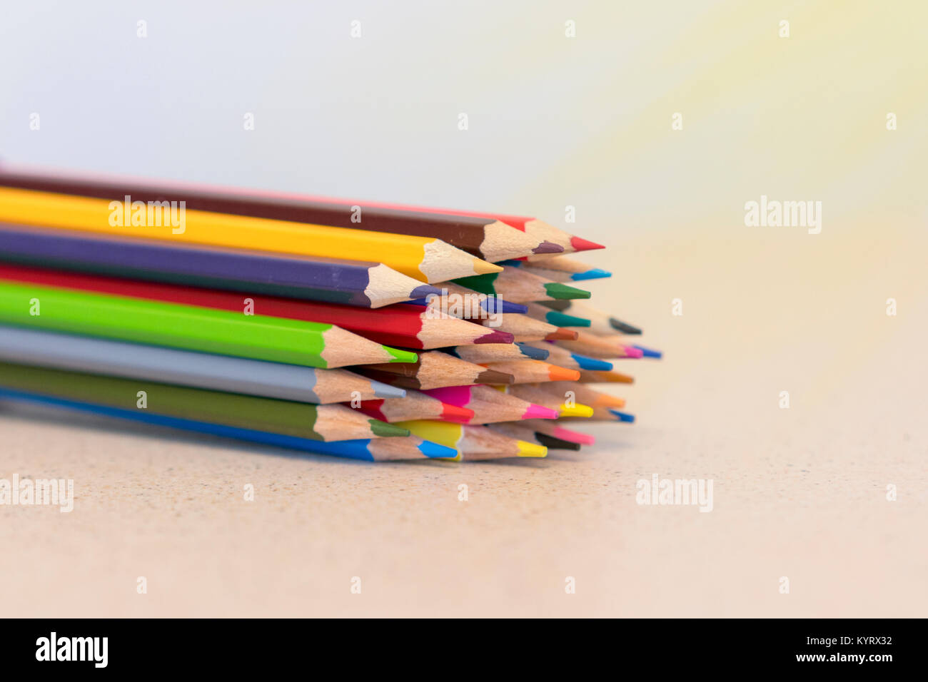 Stacked wooden coloured pencils on sunny background Stock Photo - Alamy