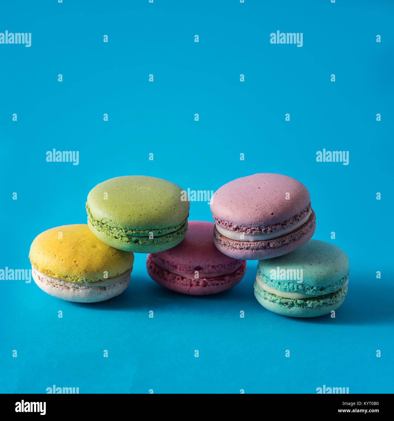 multicolored macaroon on blue background, close up Stock Photo - Alamy
