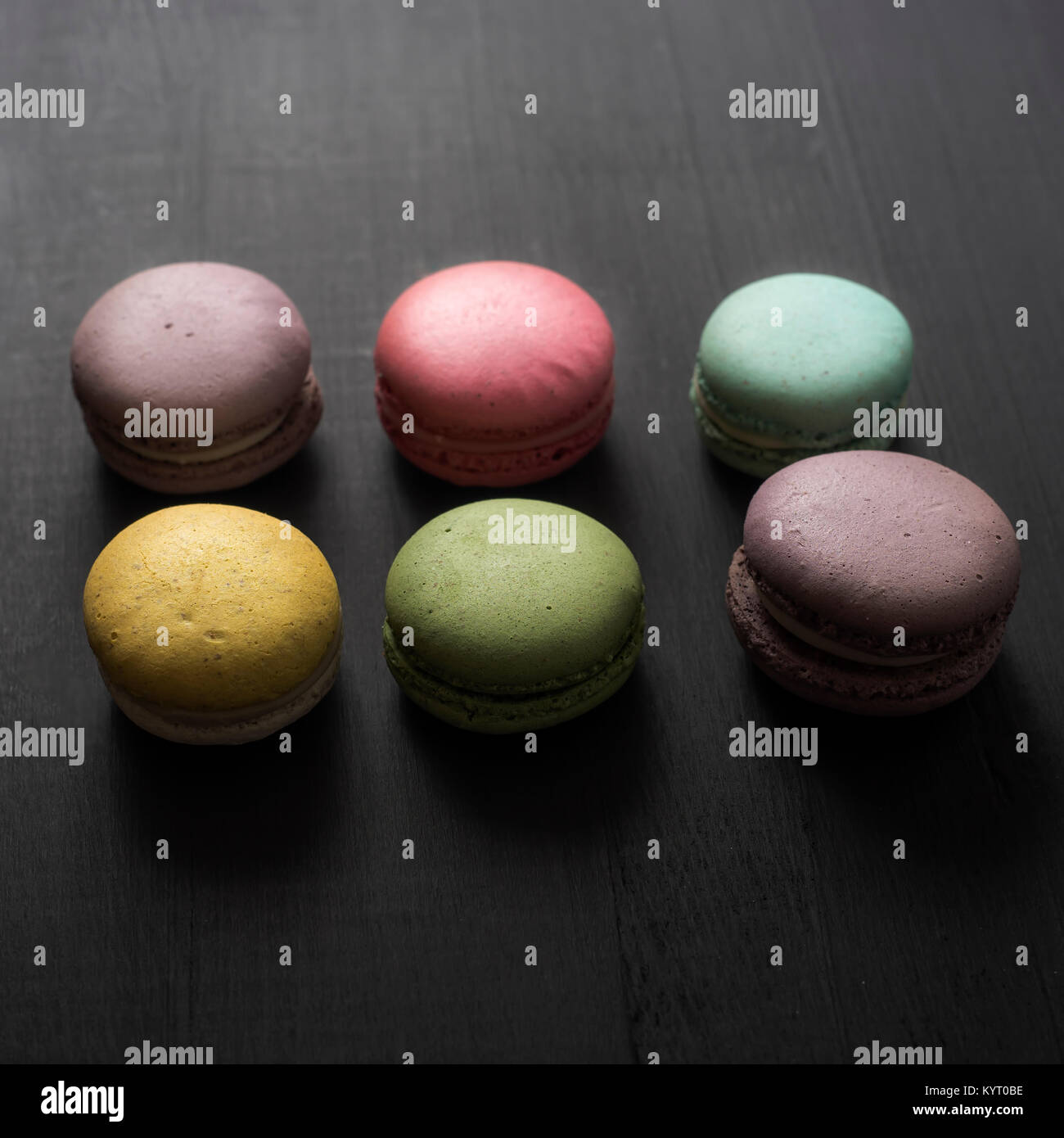 multicolored macaroon on a dark wooden table, from above Stock Photo ...