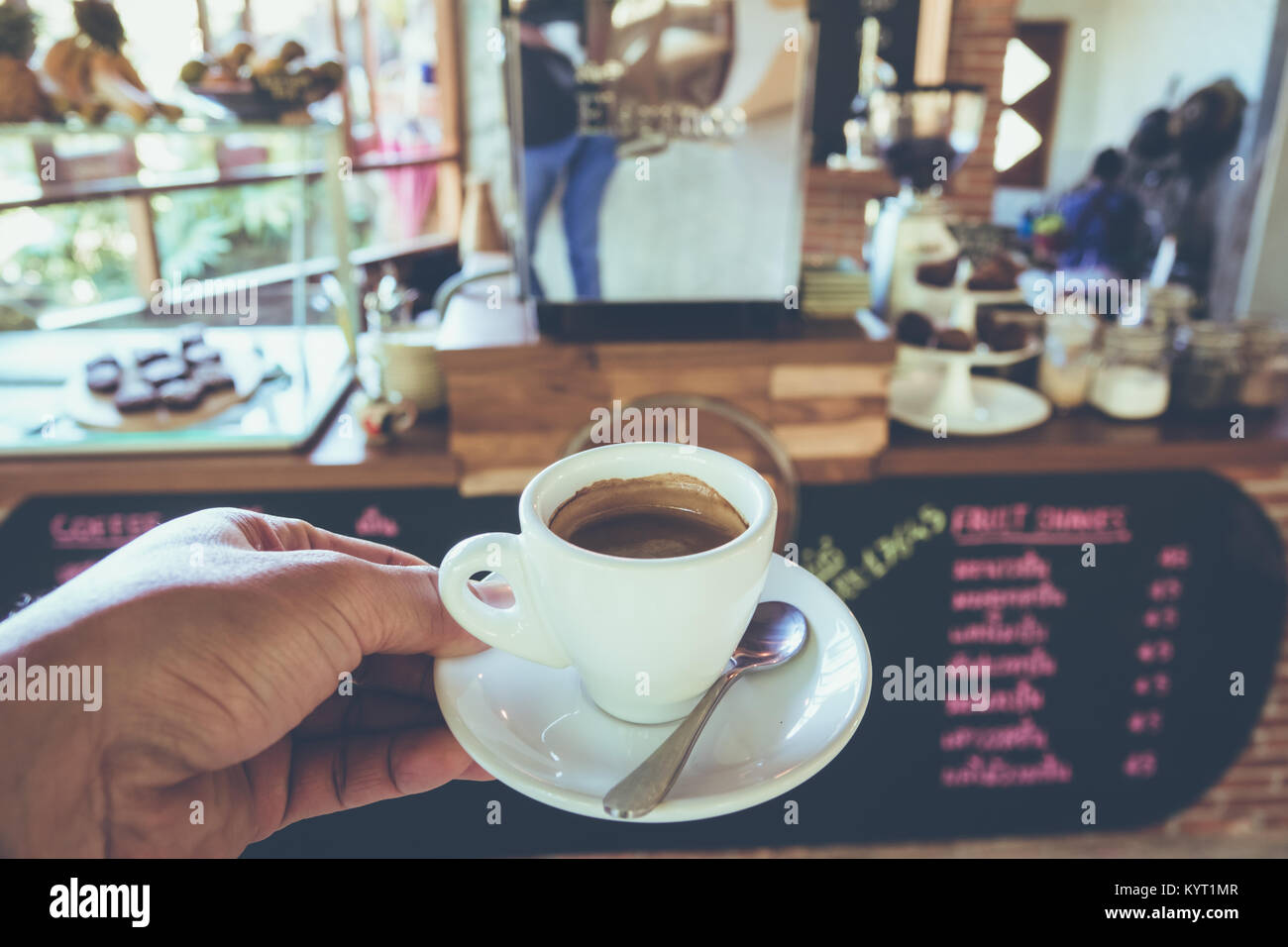 a cup of coffee on hand with coffee bar background Stock Photo - Alamy