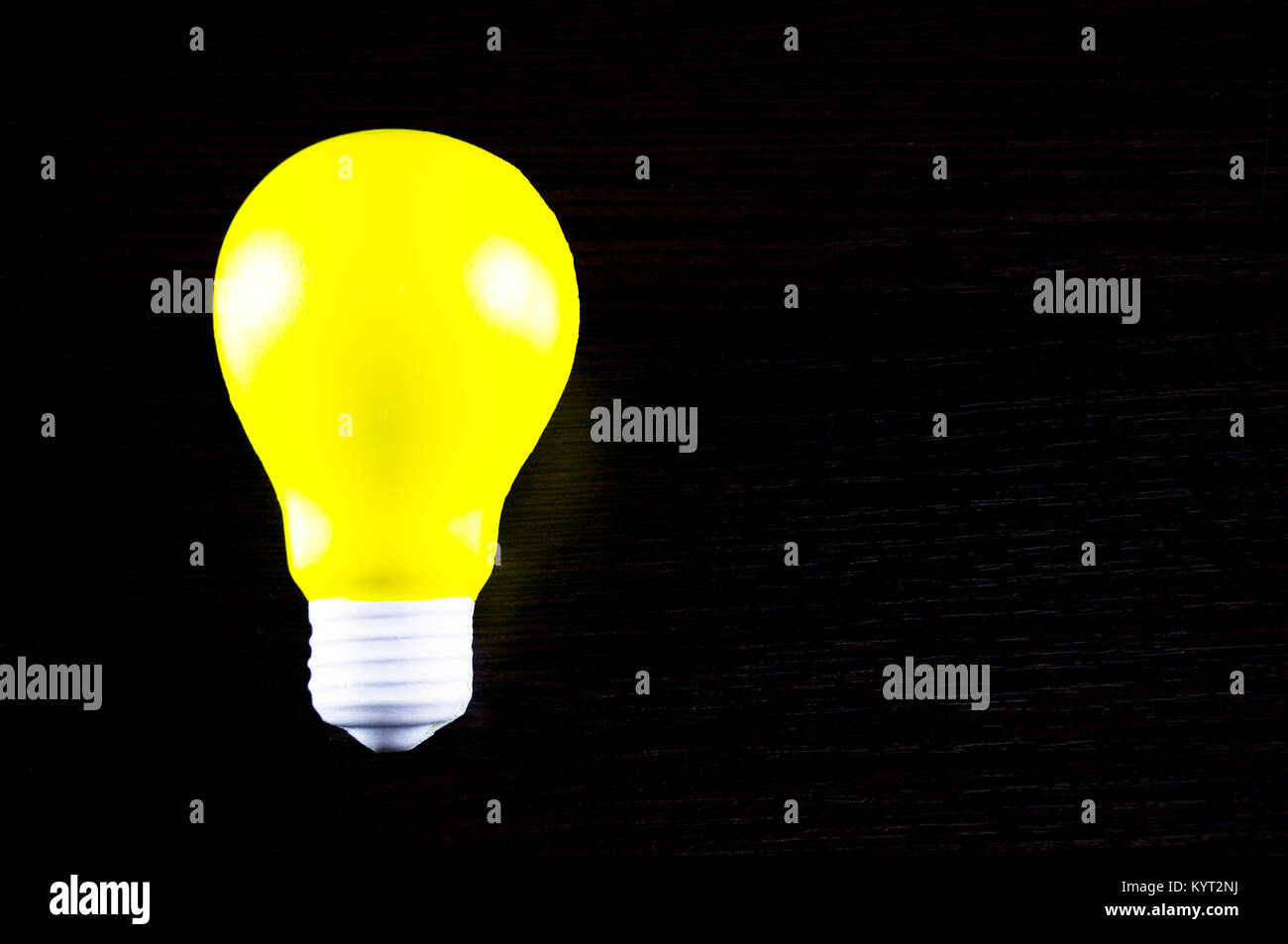yellow light bulb as a symbol of idea on a dark table Stock Photo - Alamy